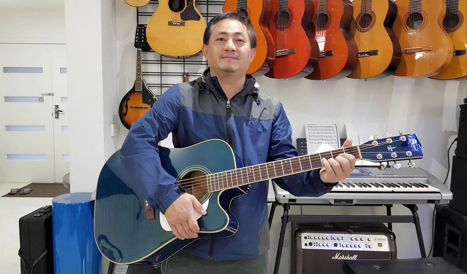 Mr Tung with his new all solid flamed maple semi-acustic guitar. His l ...